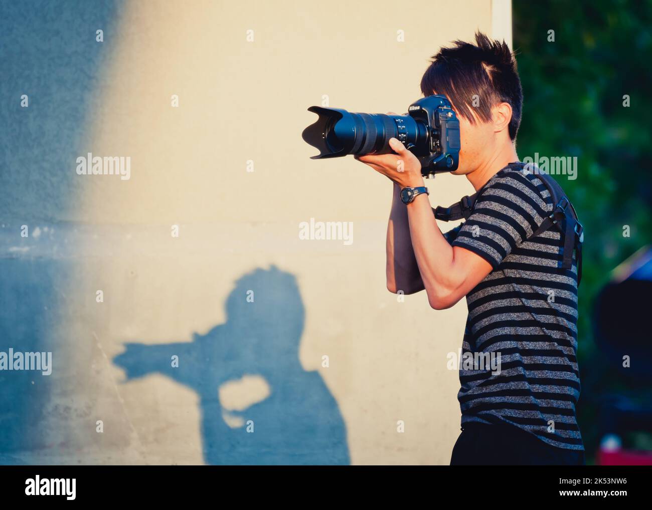 Man looking through the viewfinder of a Nikon digital camera with a ...