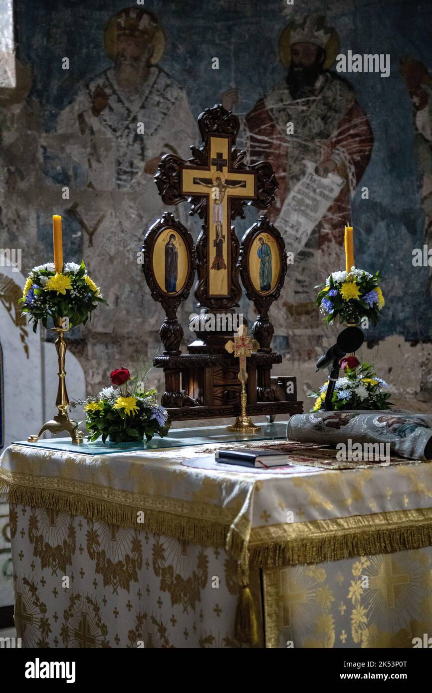 A vertical shot of a cross with candles inside the church with scenic ...