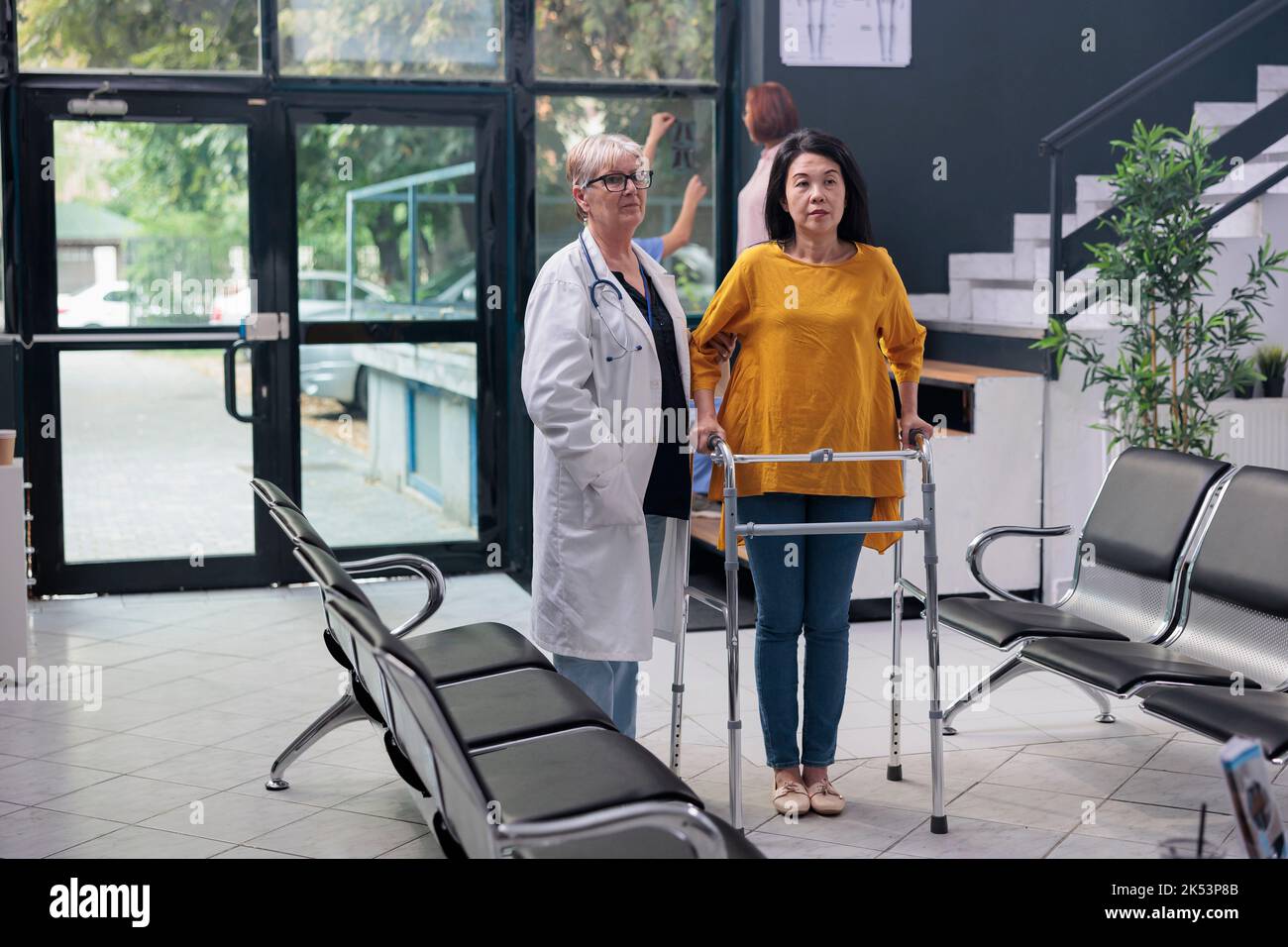 Portrait of doctor doing physical therapy exam with injured patient ...