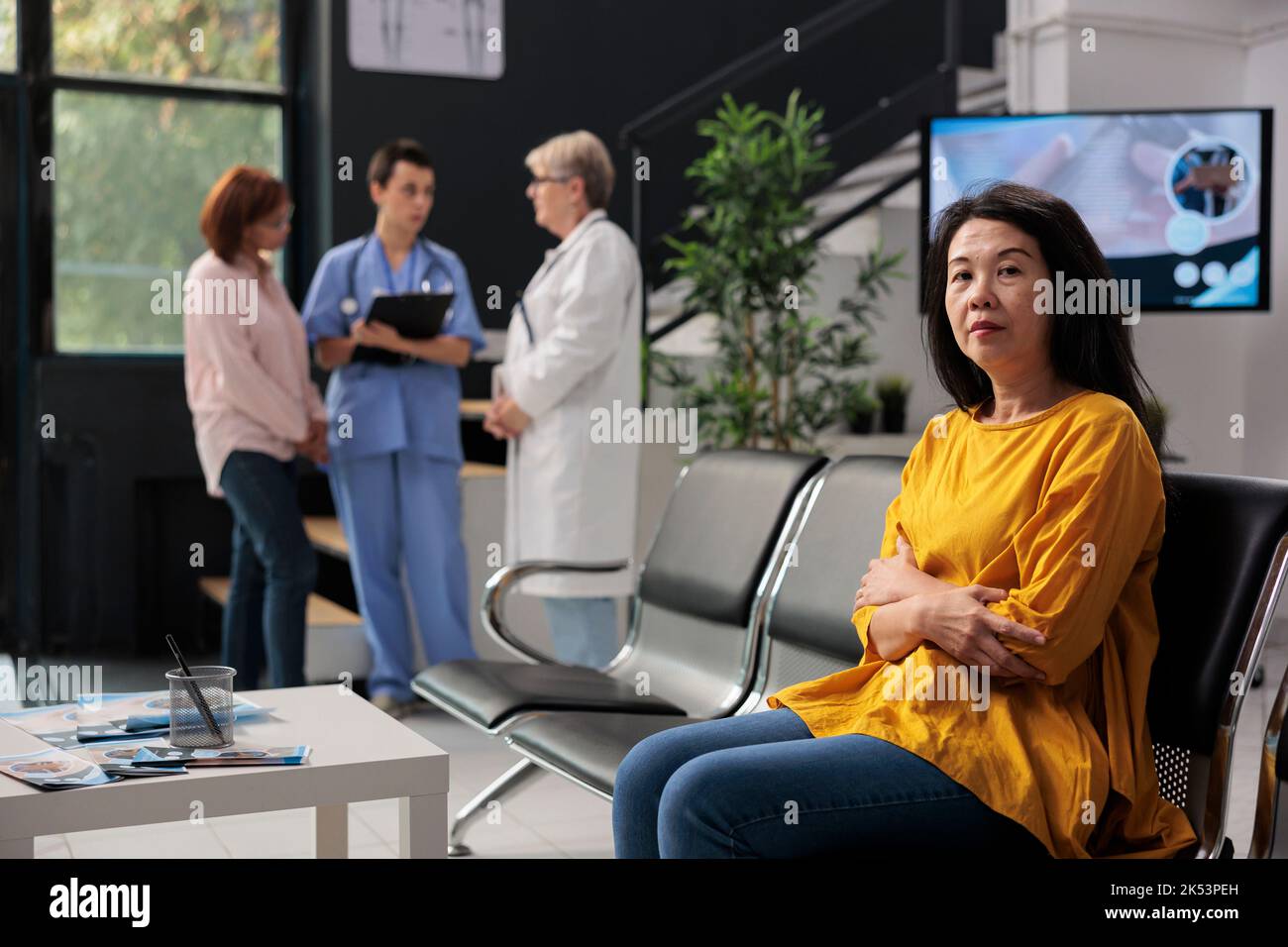Portrait of asian patient in hospital waiting area having medical ...