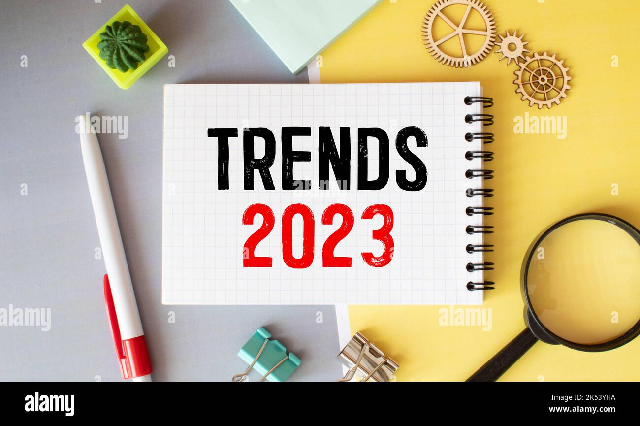 Text TRENDS 2023 on white paper between white and brown spiral notepads ...