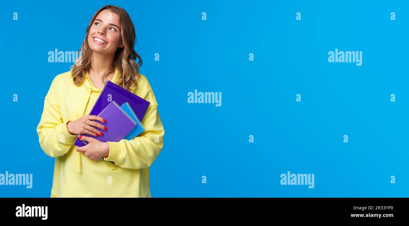 Back to school. Cute blond smiling european female student carry ...