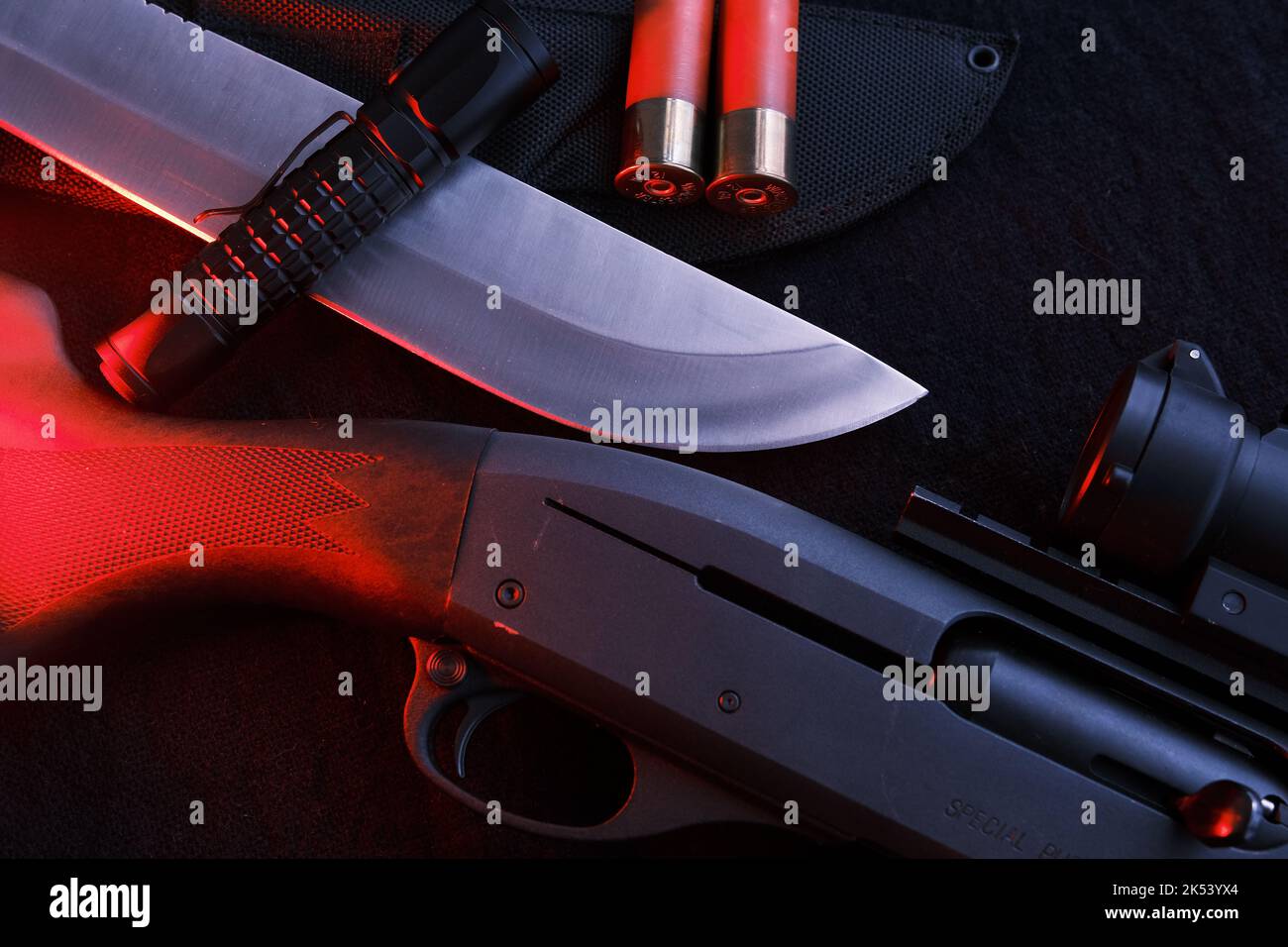 Weapon on black cloth: flashlight, knife, rifle, shells,top view. Top ...