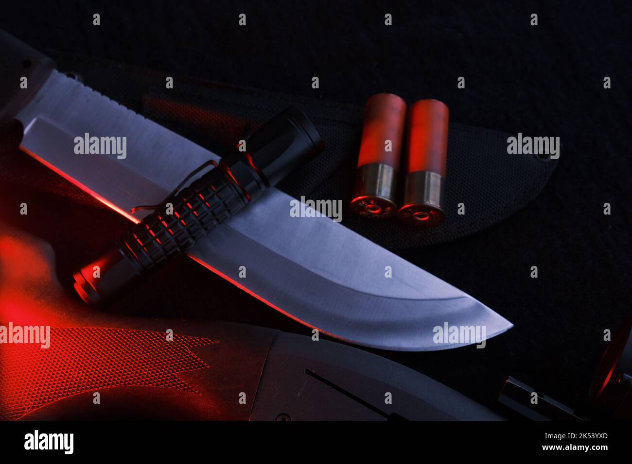 Weapon on black cloth: flashlight, knife, rifle, shells,top view. Top ...