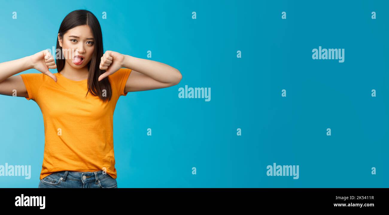 Disappointed upset and unimpressed cute childish asian girl dark haircut, frowning cringing ...