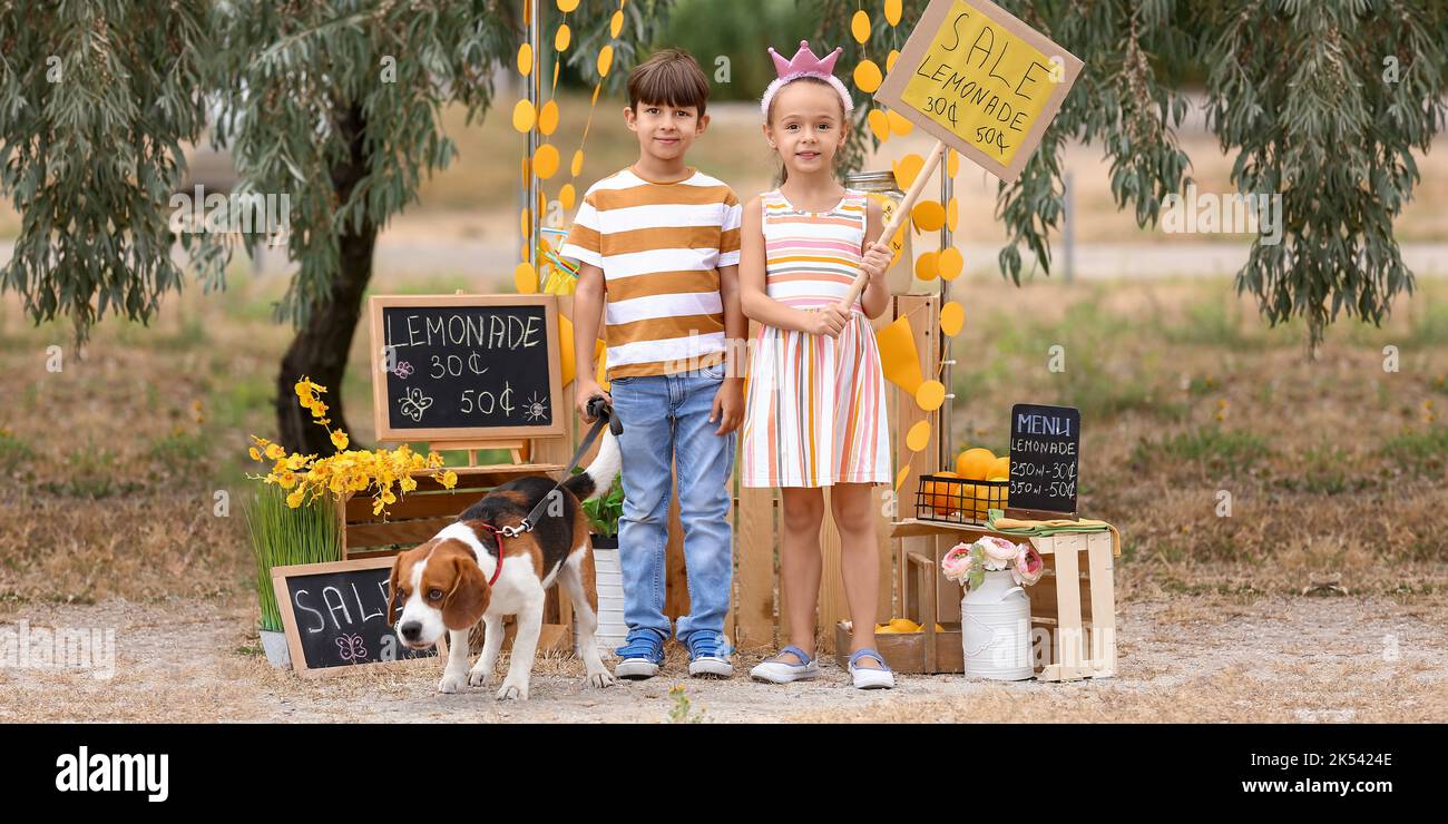 Cute little children with dog near lemonade stand in park Stock Photo ...