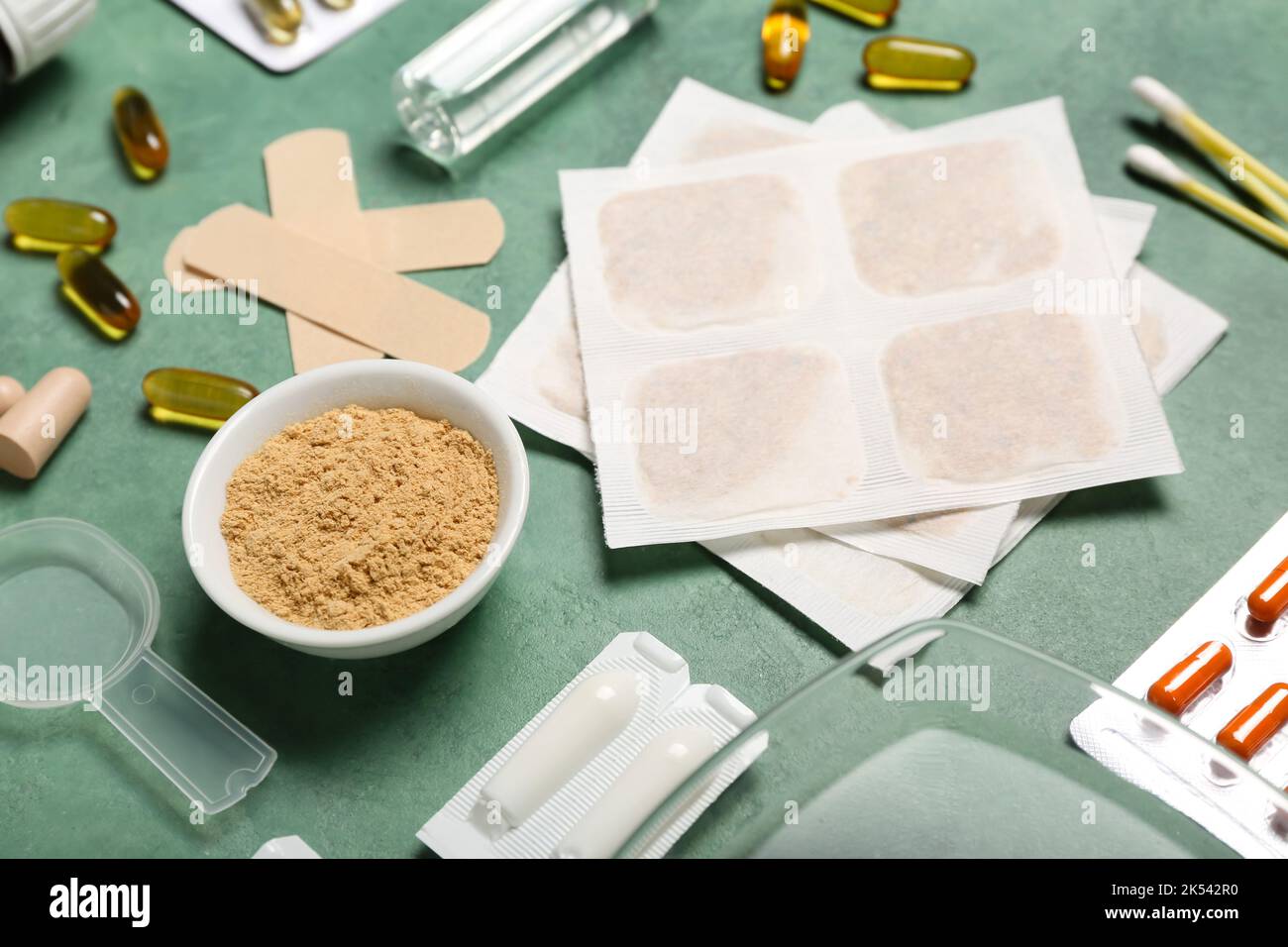 Mustard plasters with medicines on green background Stock Photo - Alamy