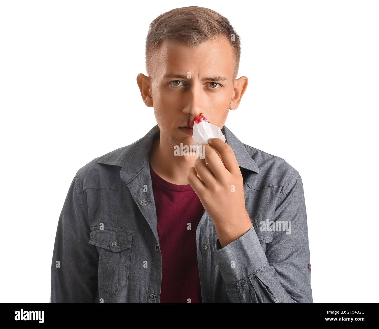 Young man wiping nosebleed with tissue on white background Stock Photo ...