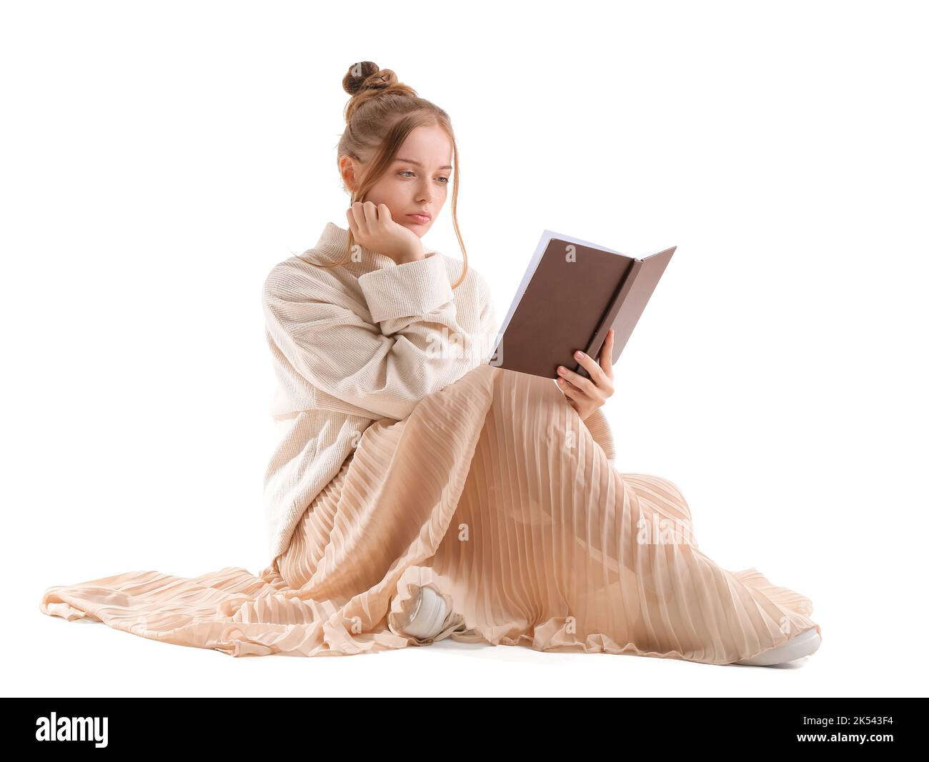 Sad young woman reading book on white background Stock Photo - Alamy