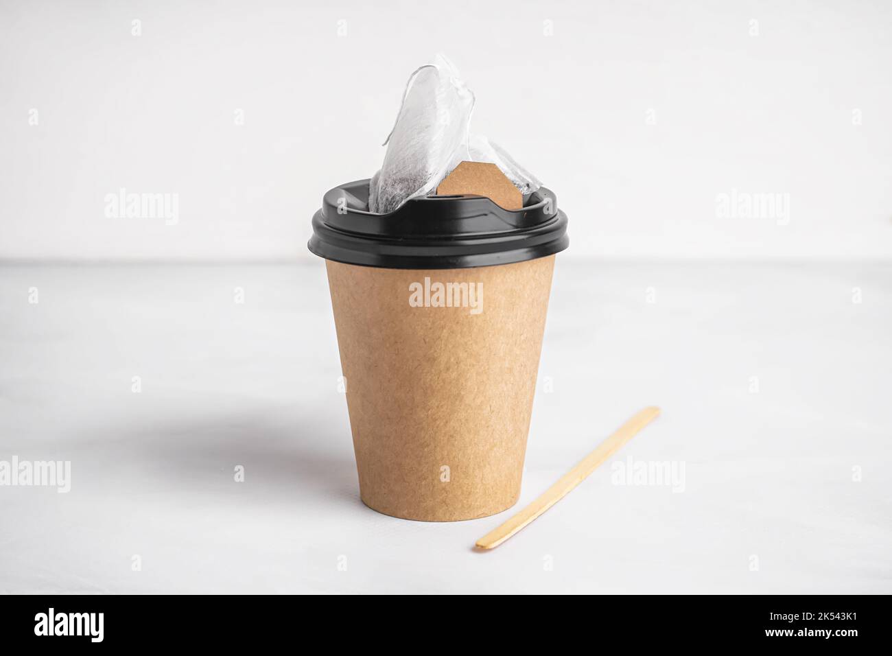Paper cup, stick and tea bag on light background Stock Photo - Alamy