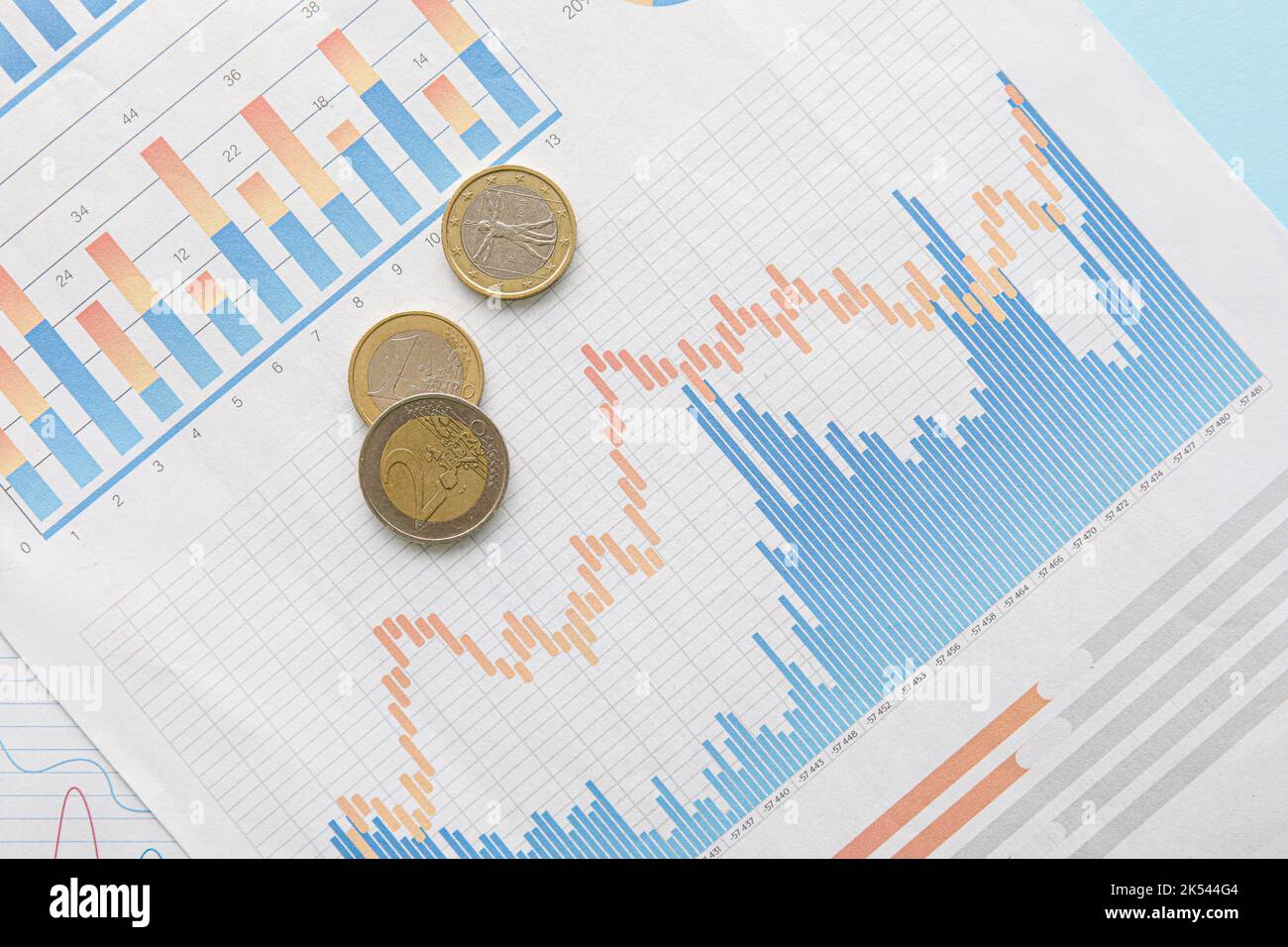 Coins and diagrams on blue background, closeup. Exchange rate concept ...