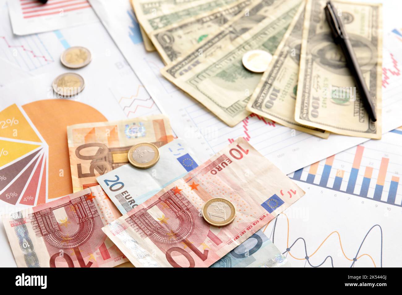Different banknotes with coins on diagrams, closeup. Exchange rate ...