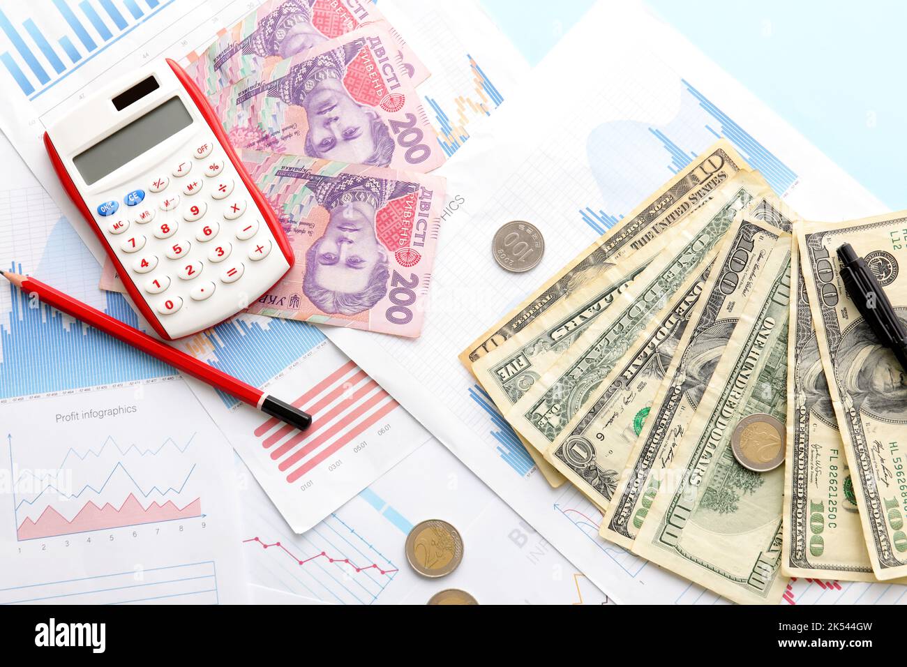 Different banknotes with coins, calculator and diagrams on blue ...