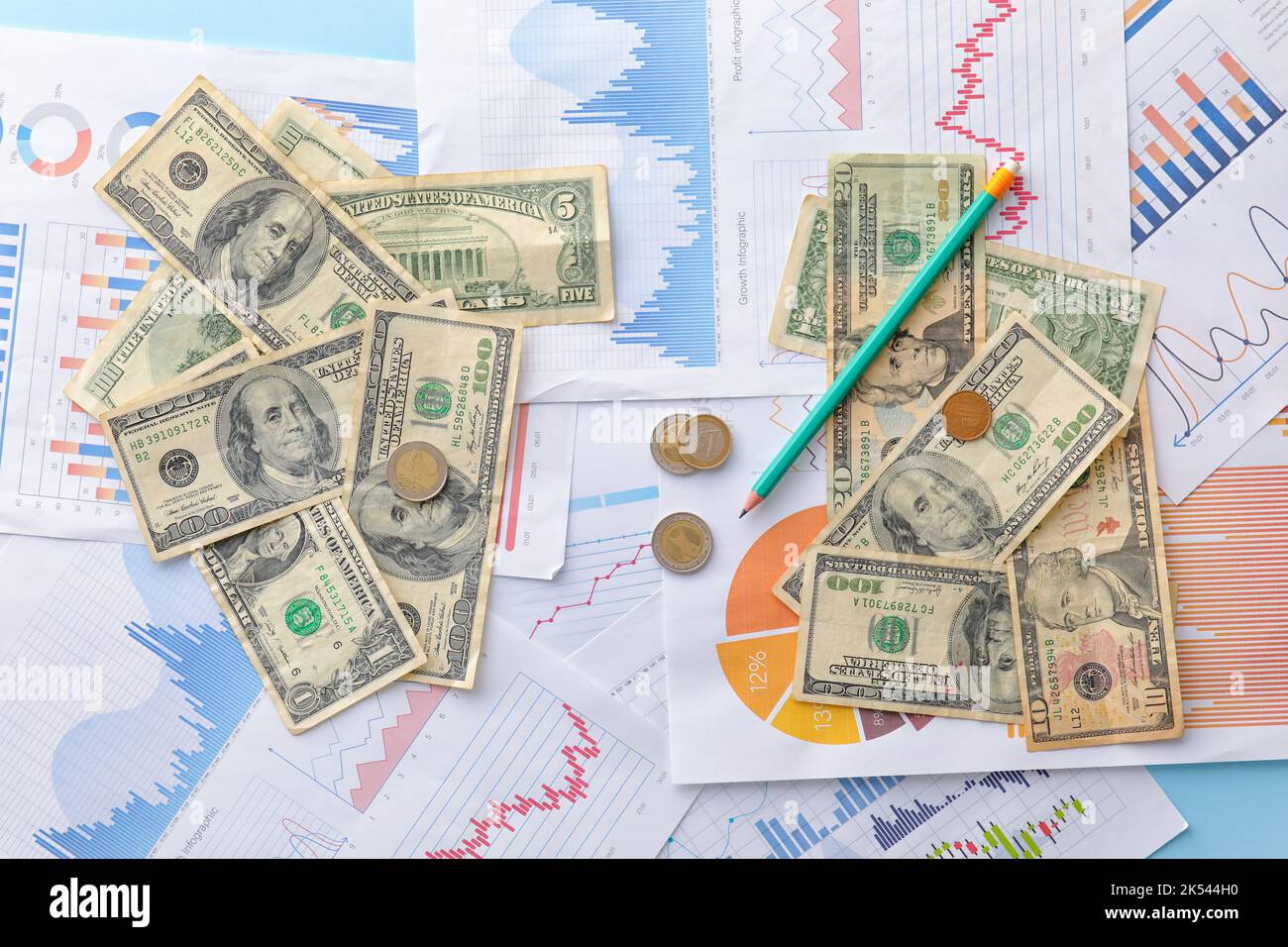 Dollar banknotes with coins, pencil and diagrams on blue background ...