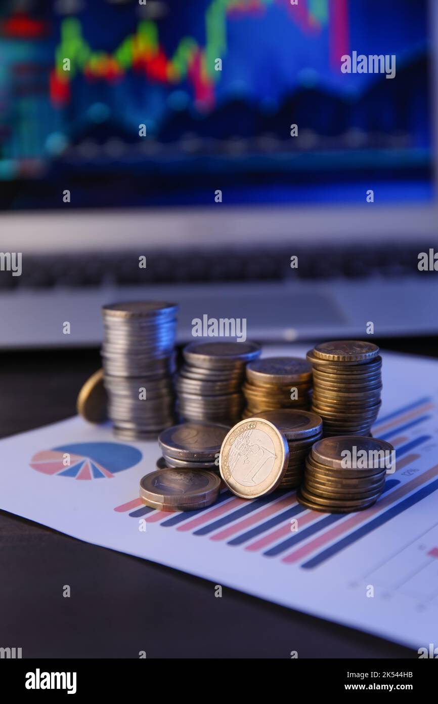 Stacks of coins on diagrams in office, closeup. Exchange rate concept ...