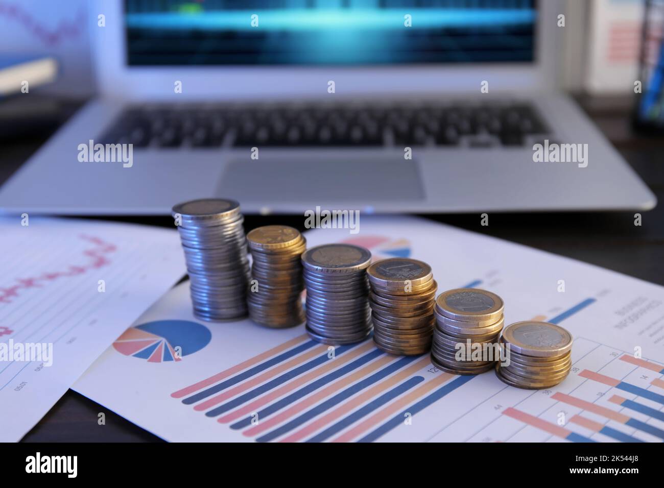 Stacks of coins on diagrams in office, closeup. Exchange rate concept ...