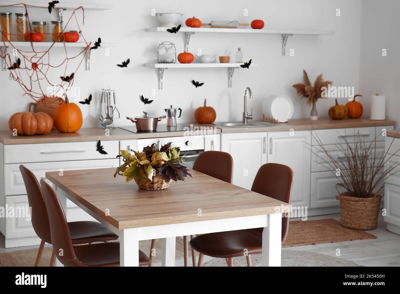 Interior of modern kitchen decorated for Halloween with pumpkins ...