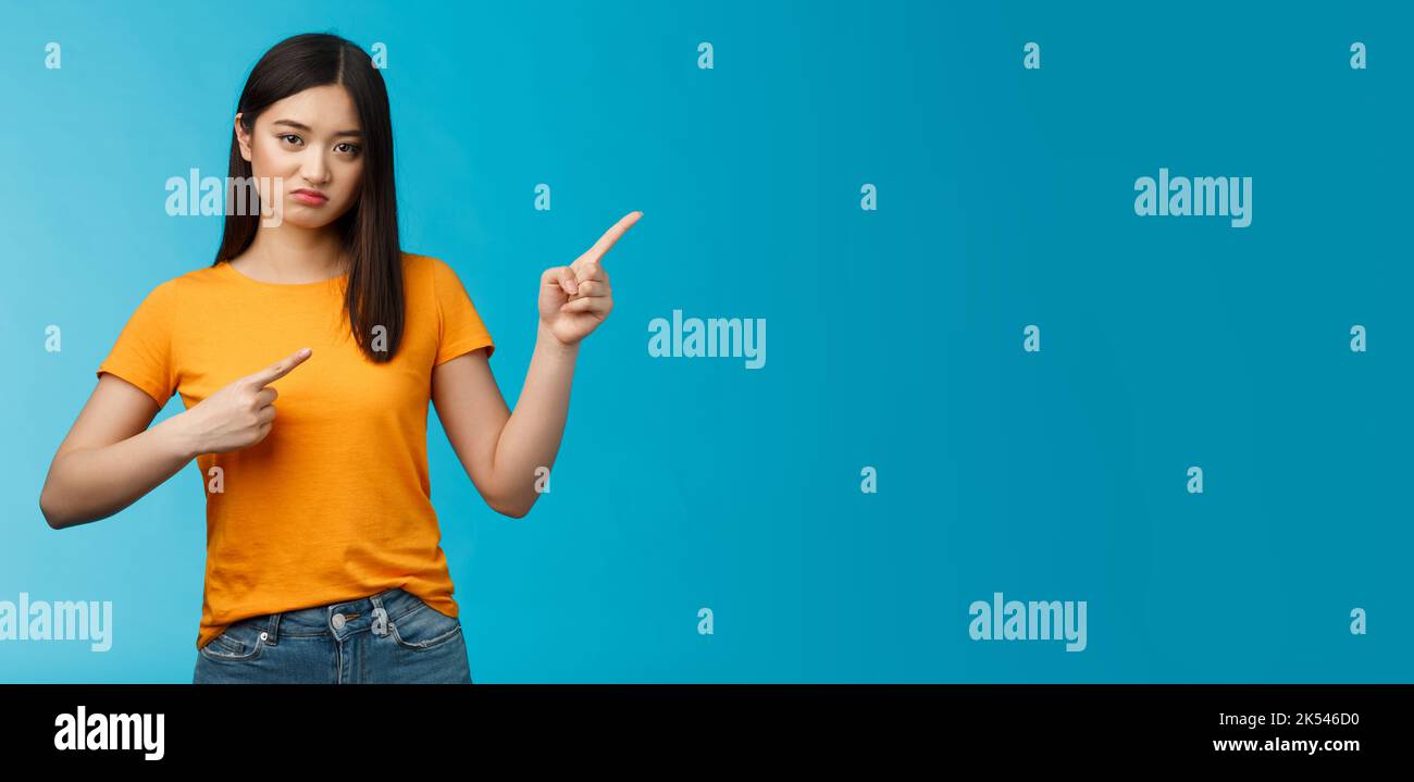 Picky disappointed asian girl with unsatisfied face, pointing upper ...