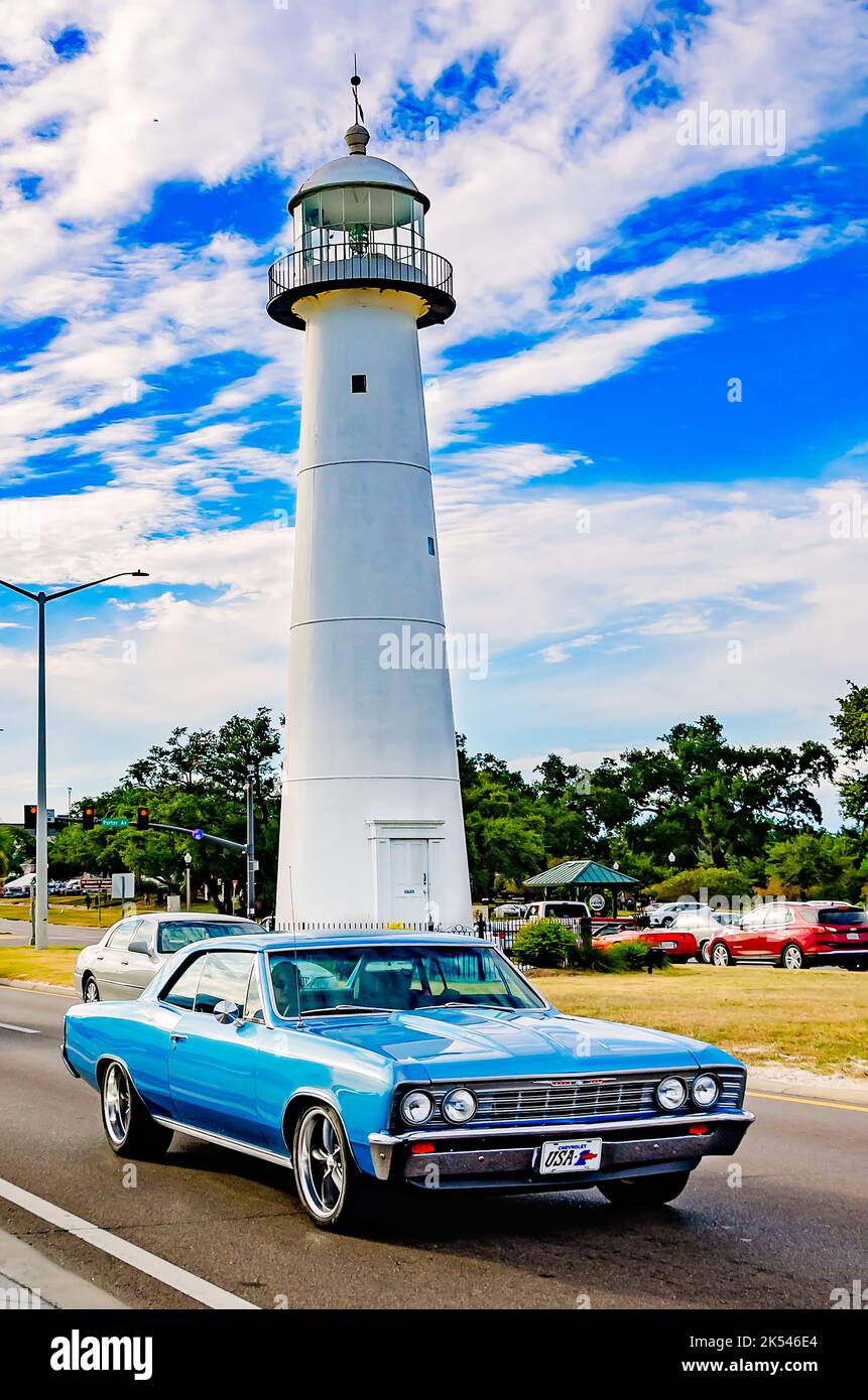 A vintage Chevrolet automobile passes the Biloxi lighthouse during the ...