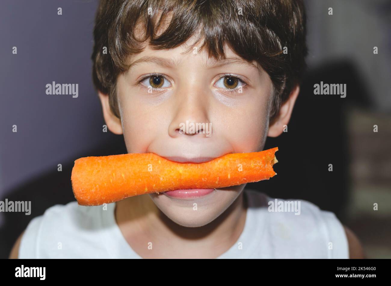 Happy little boy eating a fresh carrot and having fun. Healthy ...