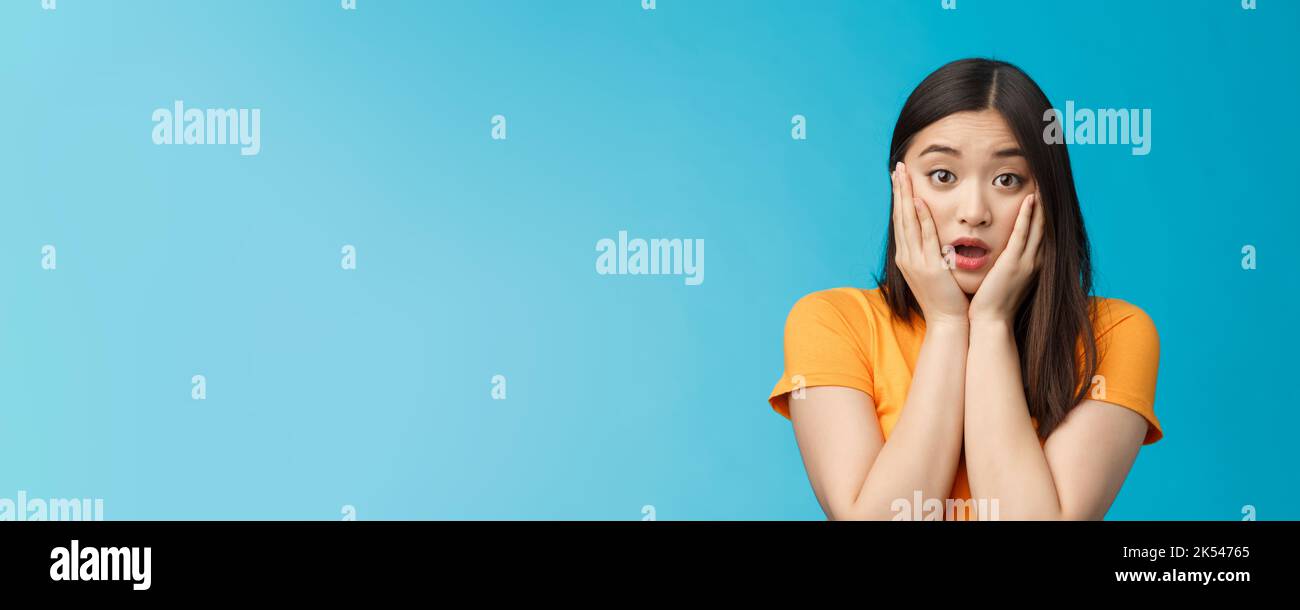 Close-up concerned shocked young timid asian girl gasping, dropping jaw ...