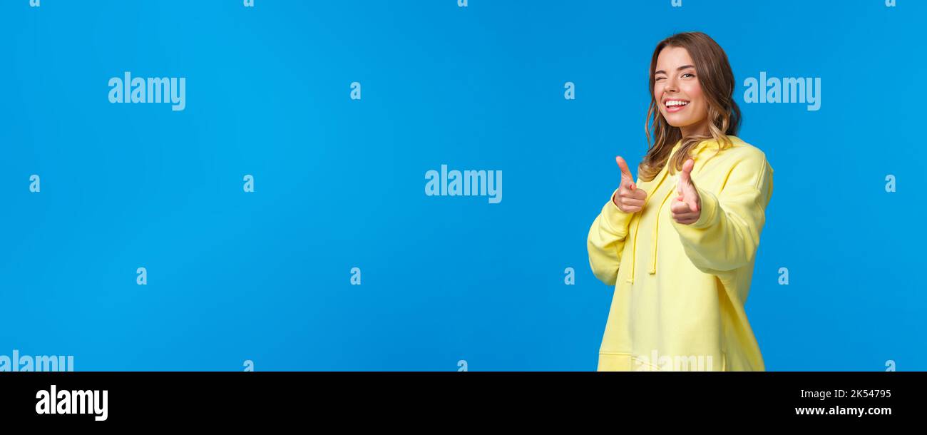 Hey you. Cheeky and carefree cute modern european girl in yellow hoodie ...