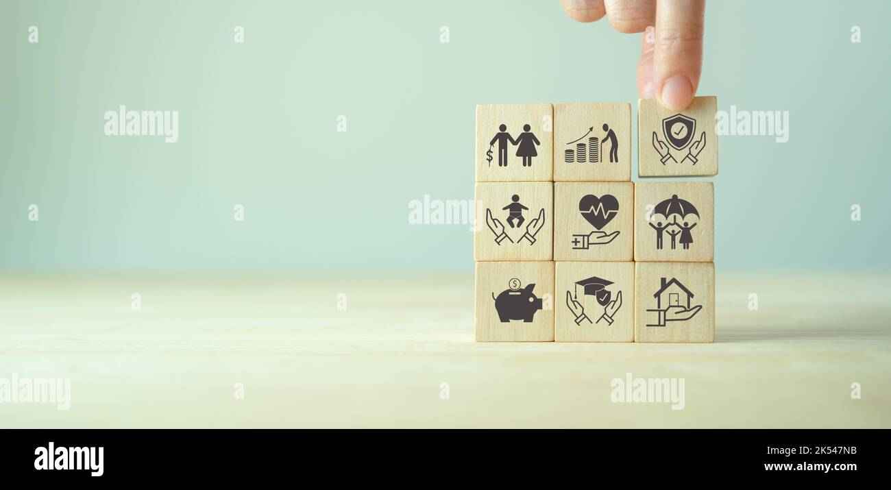 Insurance and stages of life concept. Hand puts wooden cube with ...