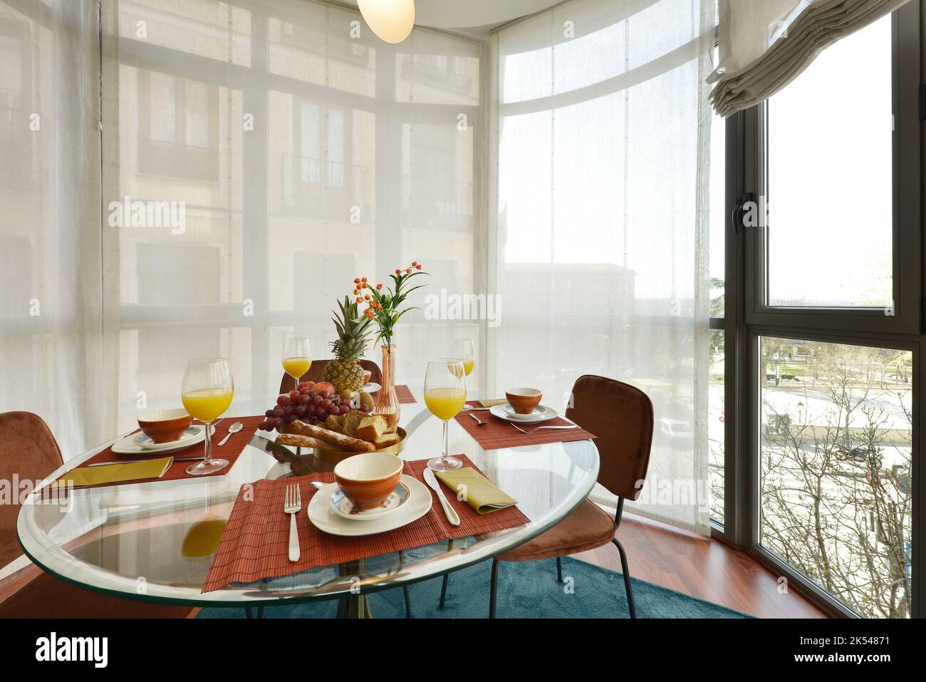 Pretty circular clear glass dining table with beveled edge surrounded ...