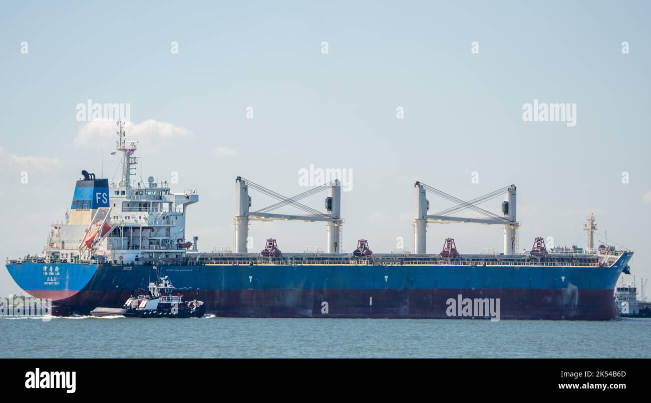 cargo ship escorted by tug boat in texas city Stock Photo - Alamy