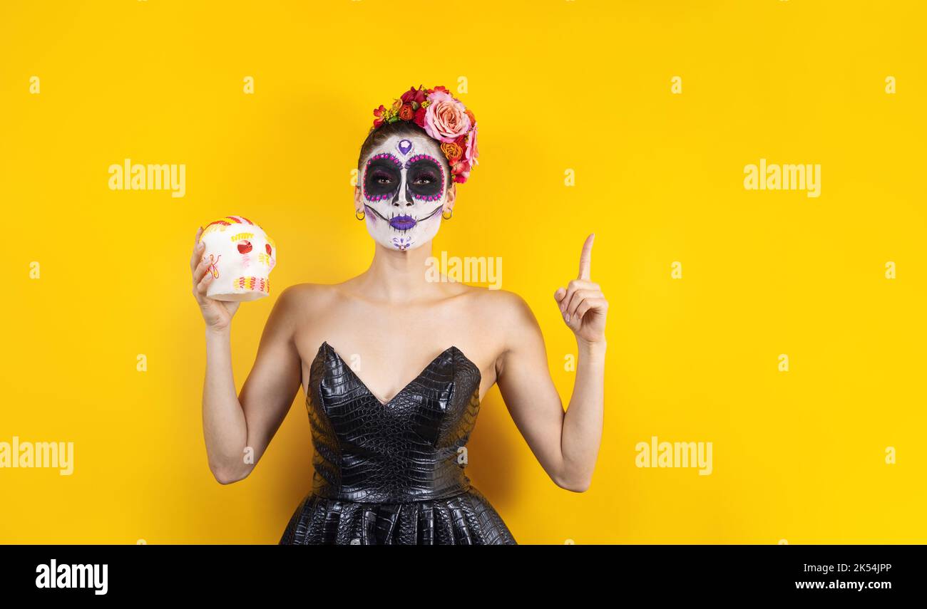 Mexican Catrina, portrait of young hispanic woman holding a sugar skull ...