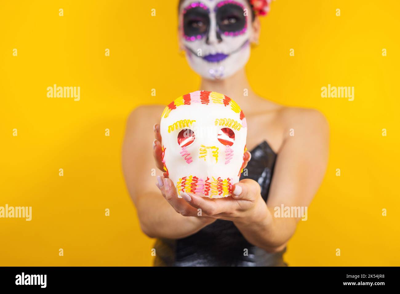Mexican Catrina, portrait of young hispanic woman holding a sugar skull ...