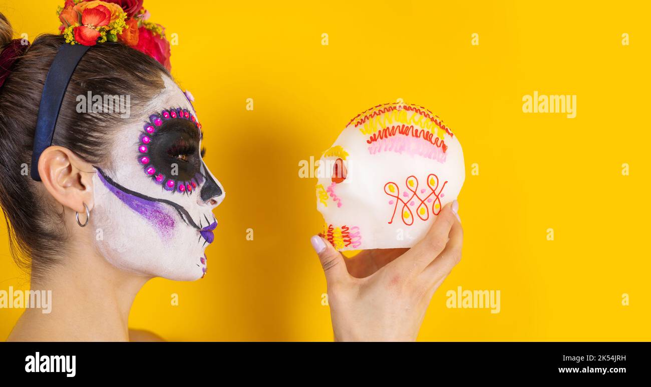Mexican Catrina, portrait of young hispanic woman holding a sugar skull ...