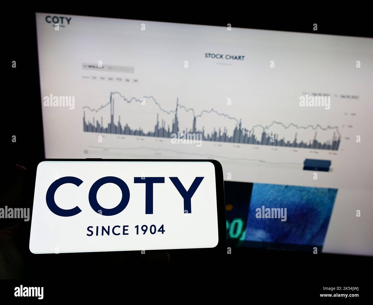 Person holding mobile phone with logo of American beauty company Coty ...