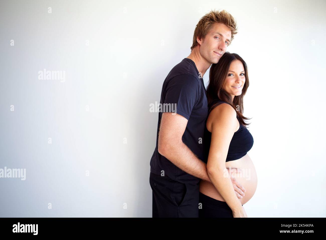 Waiting for the arrival. Portrait of a young expecting couple standing ...