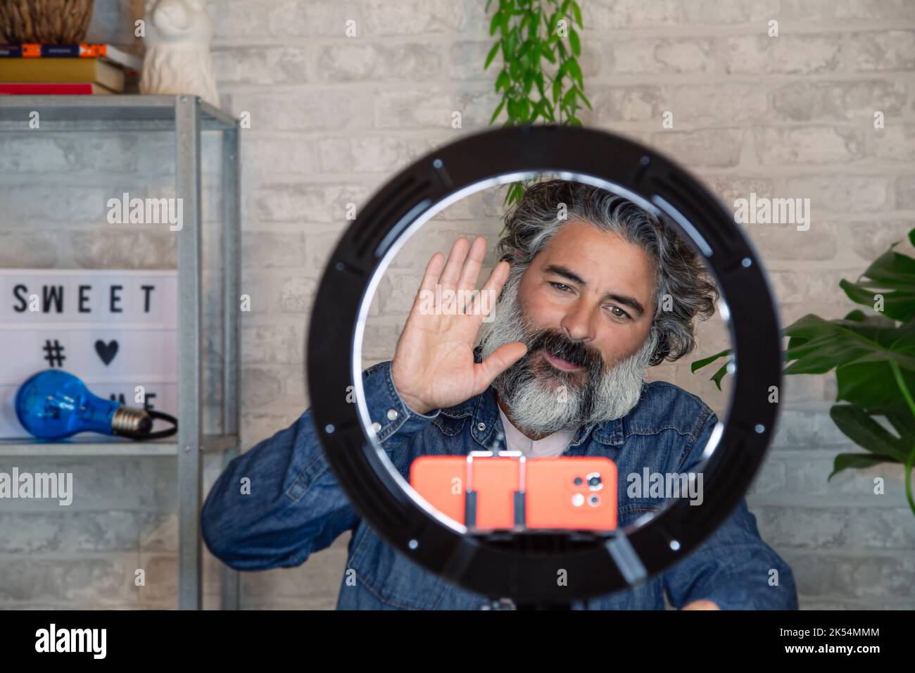 Influencer man greeting his followers. Recording himself for a tutorial ...