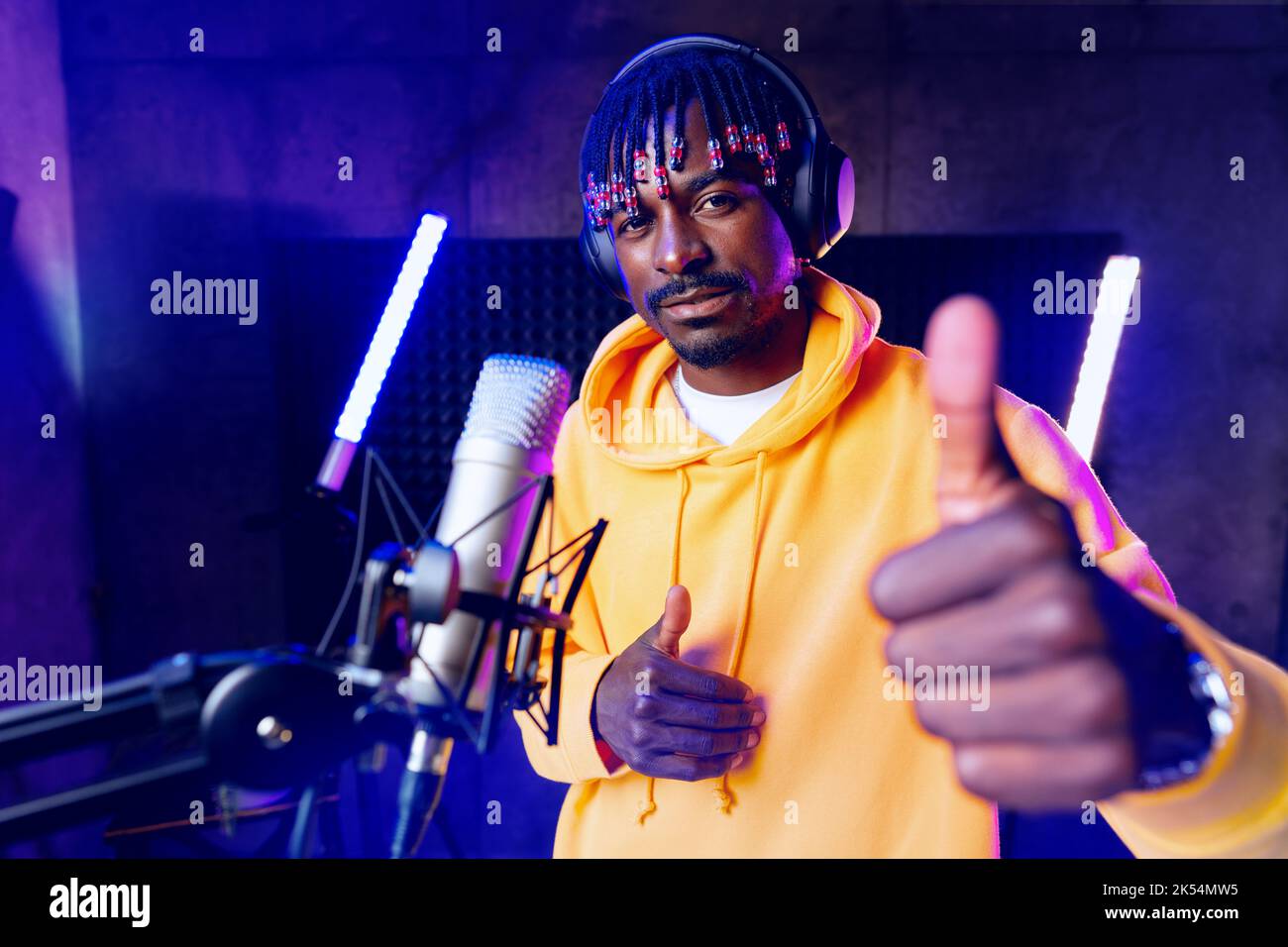 Young African performer recording his new track in recording studio ...