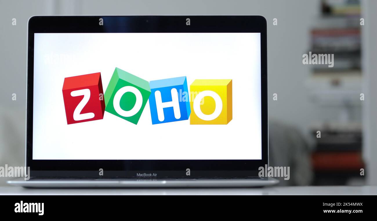 A logo design of Zoho on a laptop screen in blurred background Stock ...
