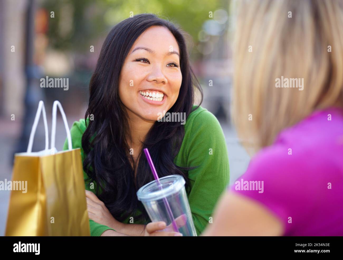 Lunch, then more shopping. Two young woman stopping for a bite to eat ...