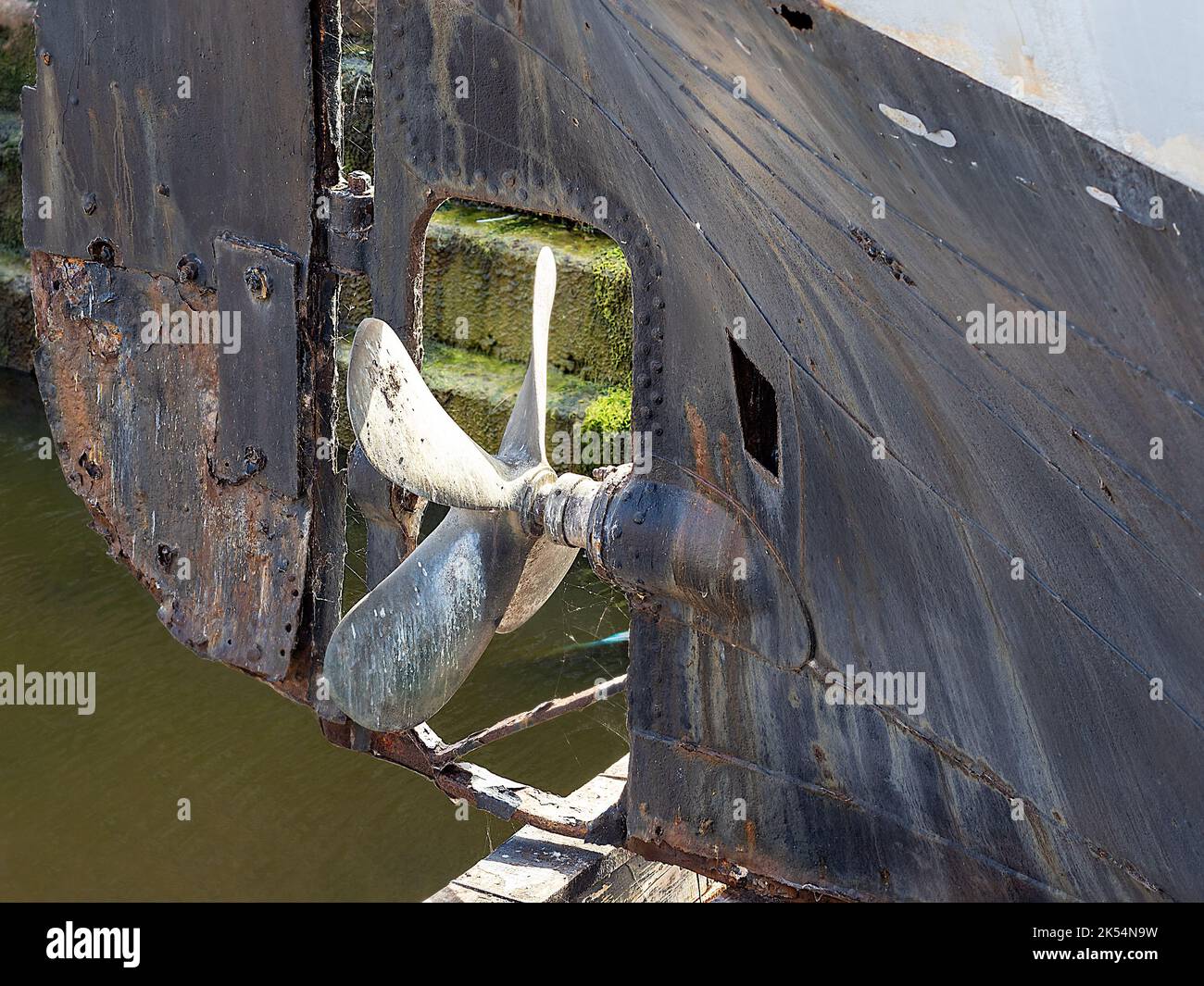 propeller and rudder on old rusty steel steamer boat in a dry dock ...
