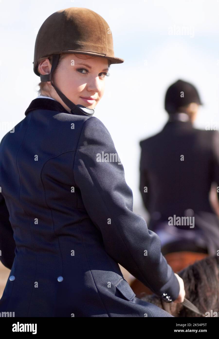 Ready for a long ride. Portrait of a young female rider mounted on her ...