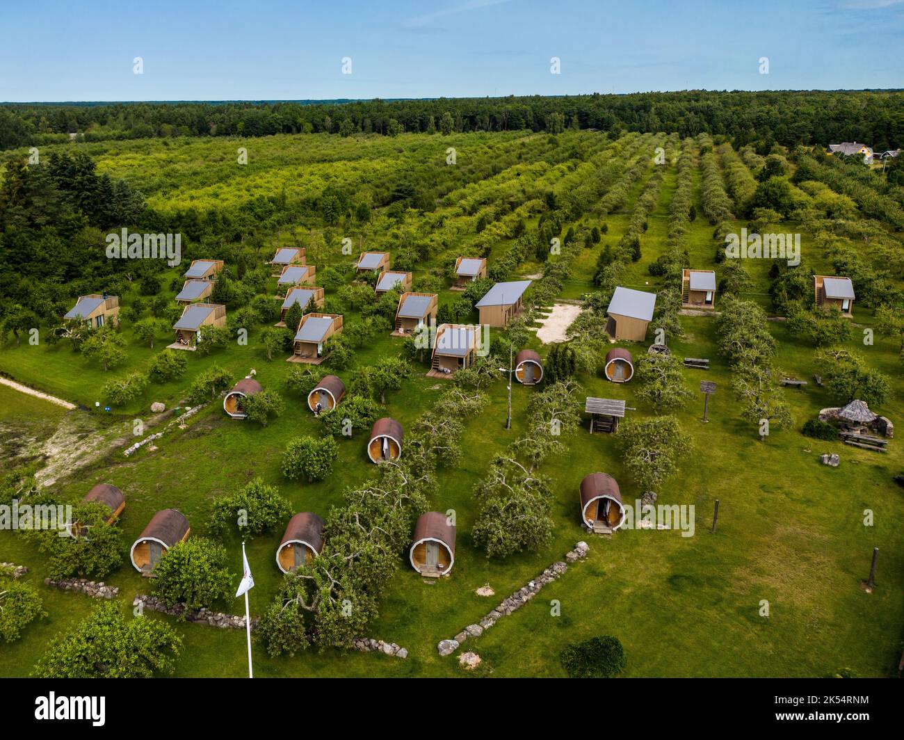 An aerial view of the wooden houses and bungalows in the green field in ...