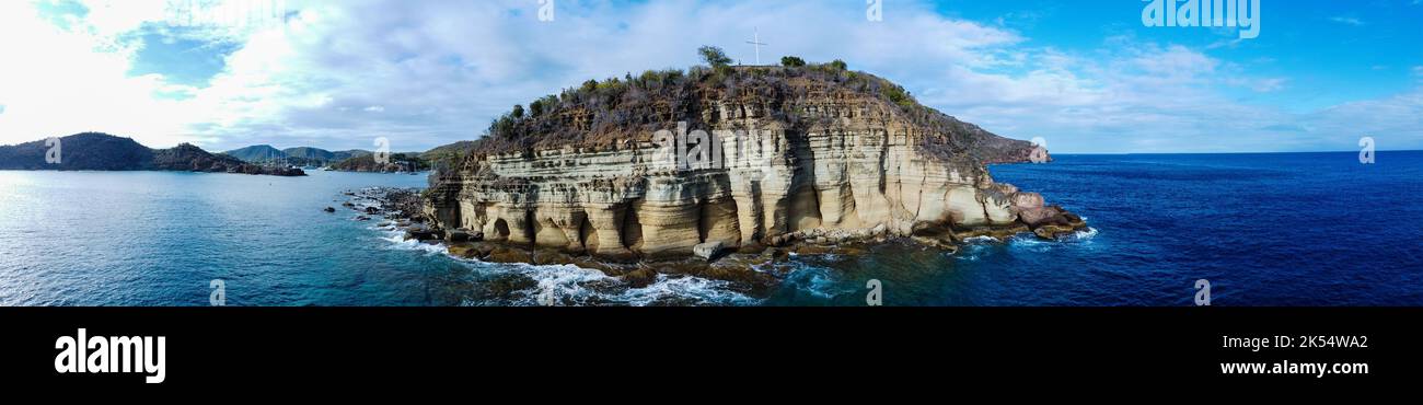 An aerial panoramic view of small rocky island in blue ocean on blue ...