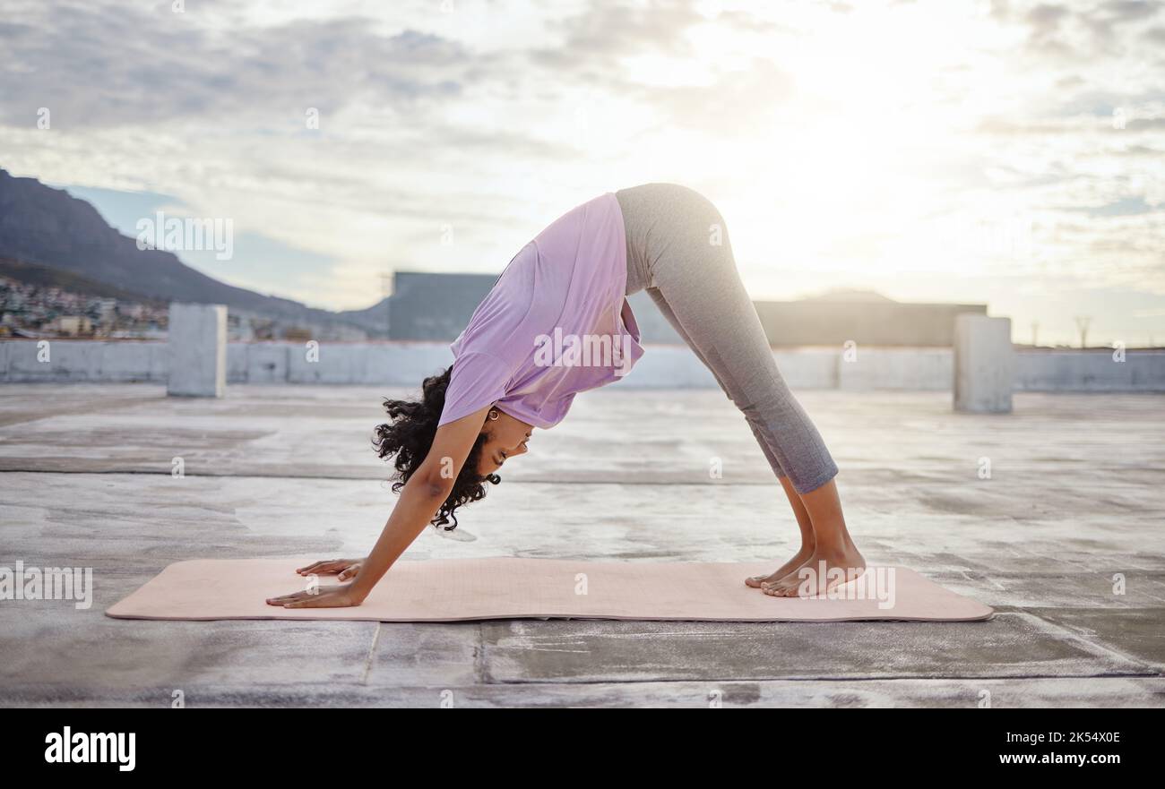 Yoga exercise, city rooftop and woman bending down for balance ...
