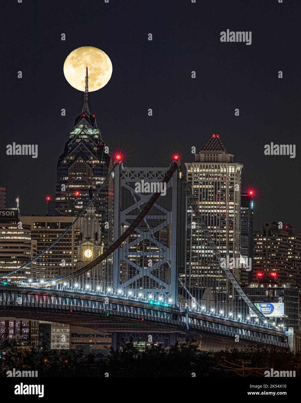 The bright yellow full moon over Philadelphia skyline with Benjamin ...