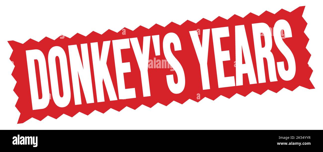 DONKEY'S YEARS text written on red zig-zag stamp sign Stock Photo - Alamy