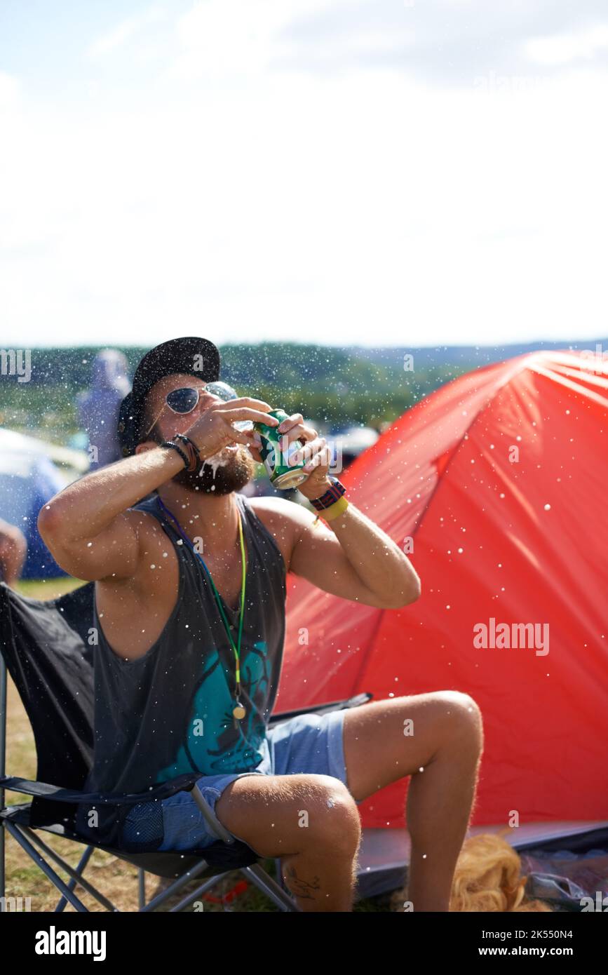 Festival culture. a guy getting drunk at his campsite at an outdoor ...