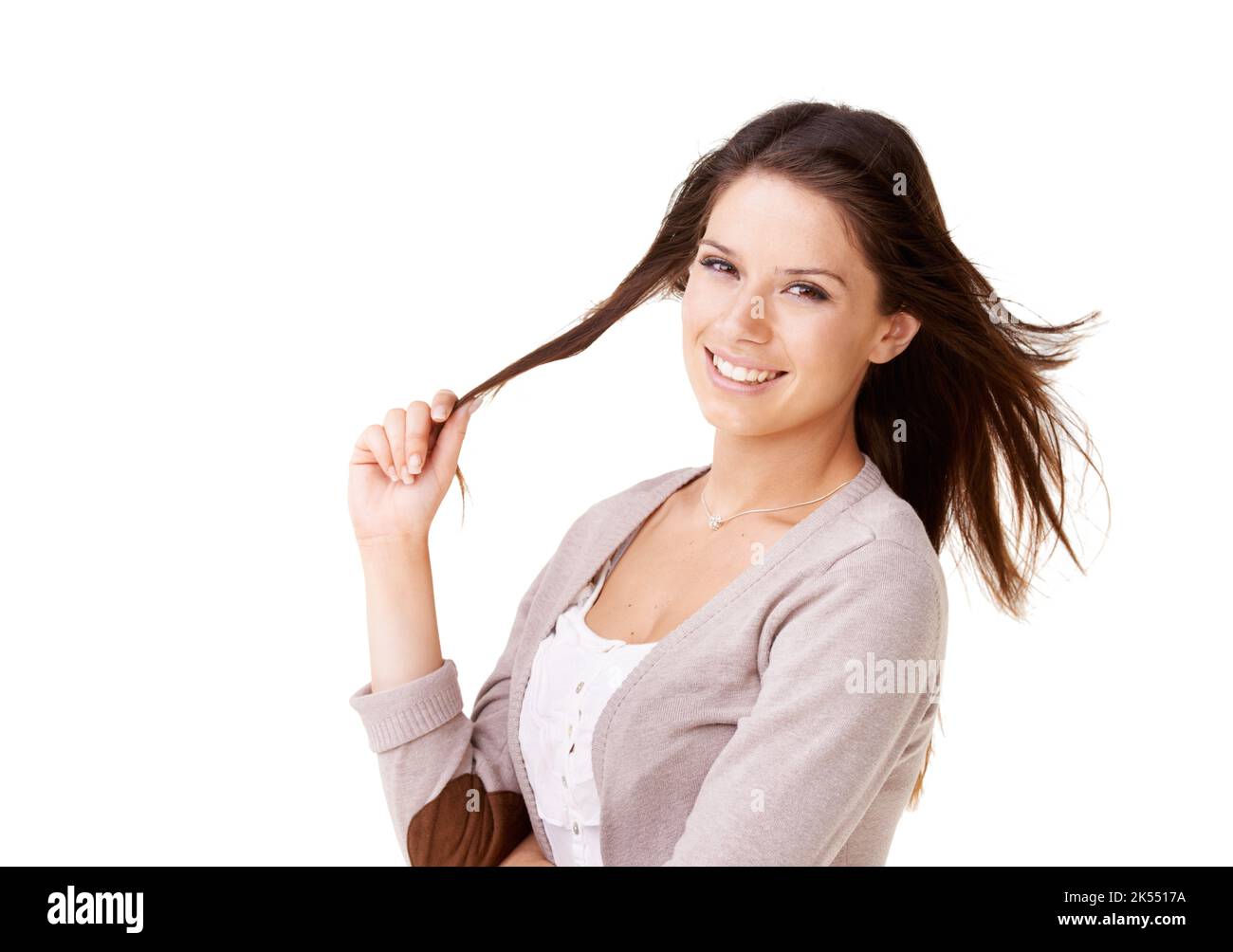 Sweet and girly. Studio shot of a beautiful young woman twirling her ...