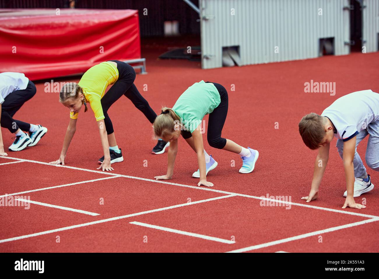Start. Group of kids getting ready to run on treadmill at the stadium ...