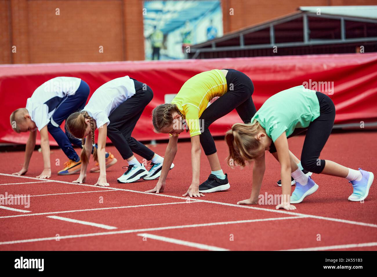 Start. Group of kids getting ready to run on treadmill at the stadium ...