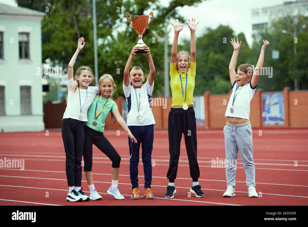 A boys and girls celebrating a victory. Motivated children team rising ...
